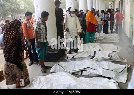 People cover their noses as they search through a line of dead bodies ...