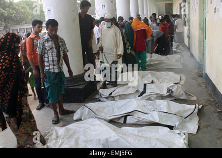 People cover their noses as they search through a line of dead bodies ...
