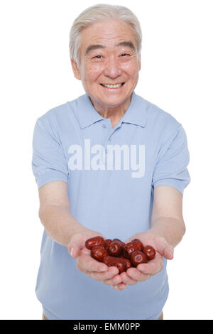 An old man holding red jujube Stock Photo - Alamy