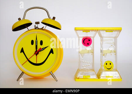 yellow alarm clock with smiley face set to 2am amongst spring primroses ...
