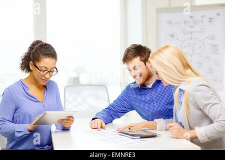 smiling team with table pc and papers working Stock Photo - Alamy