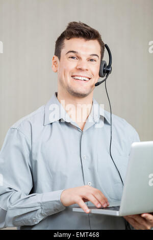 Happy male employee in headset listen to music online Stock Photo - Alamy