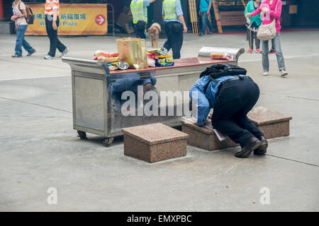A man prays and prostrates in front a table of food offerings Stock ...