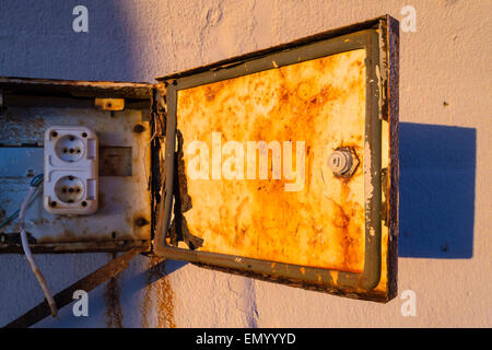 Rusty and unused electrical box with plugs and cut cables Stock Photo ...