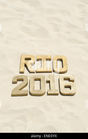 Golden Rio 2016 sign sitting on smooth sand beach background in Rio de ...