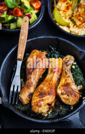 Crispy chicken legs on spinach with avocado salad Stock Photo - Alamy