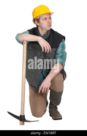 Worker crouching with pick-ax Stock Photo - Alamy