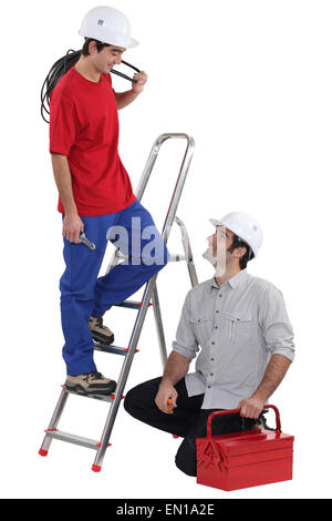 Teamwork, Two Electricians working together Stock Photo - Alamy