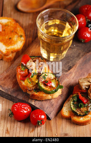 Delicious Italian bruschetta on white plate. Toasted bread topped with ...