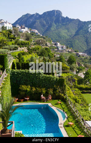 View at a terrace with a swimming pool, a sunshade and garden furniture ...