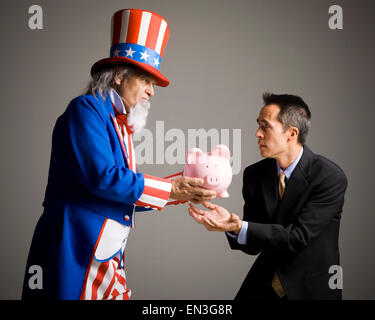 uncle sam holding up two bags of money Stock Photo - Alamy