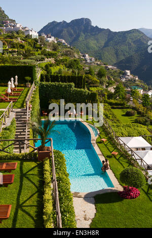 View at a terrace with a swimming pool, a sunshade and garden furniture ...