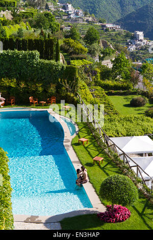 View at a terrace with a swimming pool, a sunshade and garden furniture ...