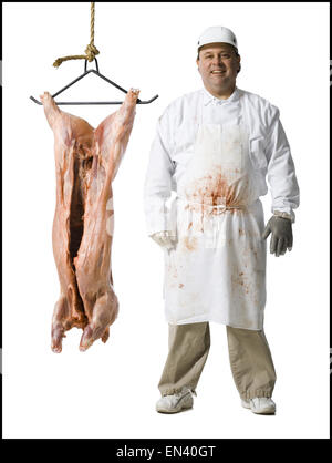 Butcher standing with hanging carcass and knife Stock Photo - Alamy