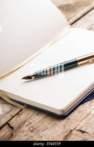 opened notebook with fountain pen on on old wooden boards painted blue ...