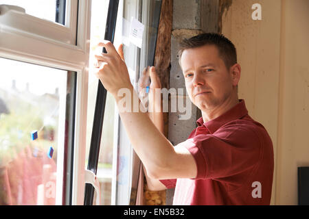 Construction worker installing new window in house Stock Photo - Alamy