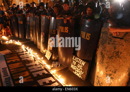 Makati, Philippines. 28th Apr, 2015. A young girl lights a candle in ...
