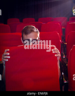 Young man watching a scary 3d film Stock Photo - Alamy