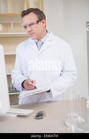 Serious and thoughtful scientist working in laboratory with microscope ...