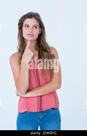 thoughtful young woman with finger on chin gesture - yellow orange ...