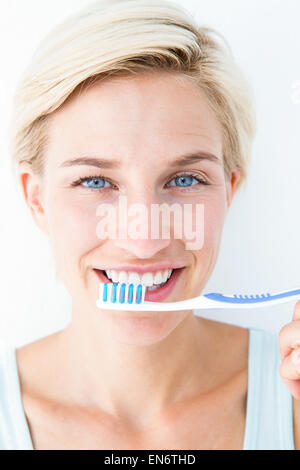 Happy woman with toothbrush looking at camera Stock Photo - Alamy