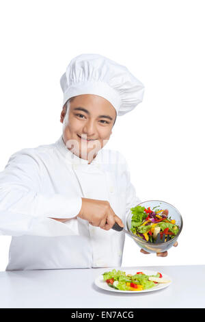 chef serving vegetable salad on plate in restaurant kitchen Stock Photo ...