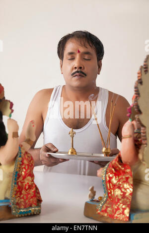 a hand performing hindu ritual pooja yajna indoor with flowers and ...
