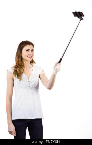 Pretty woman using a selfie stick Stock Photo - Alamy
