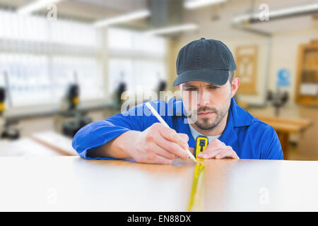 Composite image of worker measuring table Stock Photo - Alamy