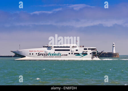 A speed ferry approaching Dover harbour with a white lighthouse in the ...