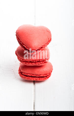Pink heart homemade macaron cookies on parchment paper on a baking ...