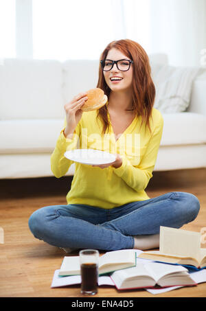 Girl doing homework and eating junk food Stock Photo - Alamy