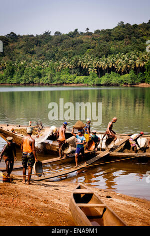 Manually offloading sand from a boat on the Mandovi River in Goa, India ...