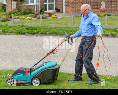 Old man mowing the grass verge by the roadside in West Sussex, England ...
