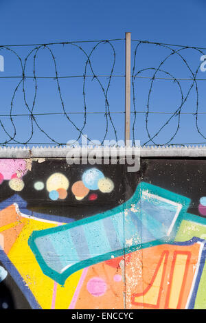 Graffiti on metal fence with barbed wire Stock Photo - Alamy