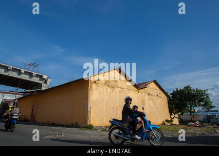 Motorists are photographed in a background of a warehouse building, in ...