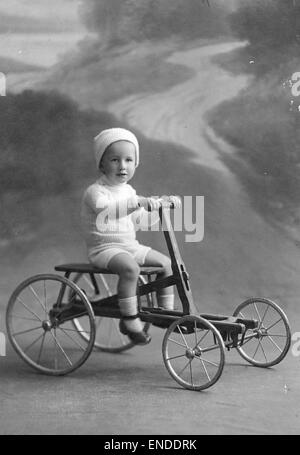 A photograph of Selwyn Howie riding his toy quadricycle around 1918 ...