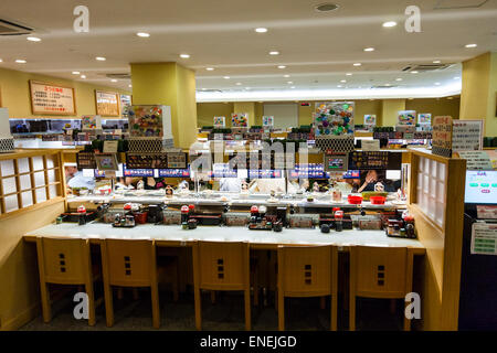 interior of a typical Japanese conveyor belt sushi restaurant. People ...