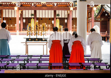 A Japanese shrine maiden (miko) bows during a ritual Stock Photo ...