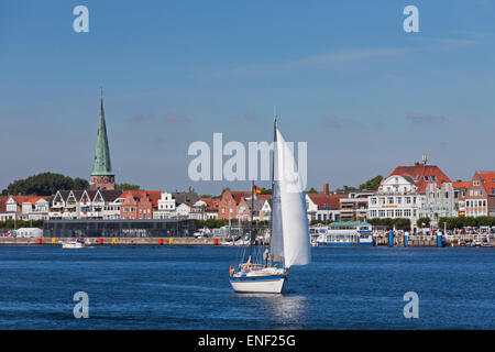 A boat sailing on the Trave river surrounded by traditional buildings ...