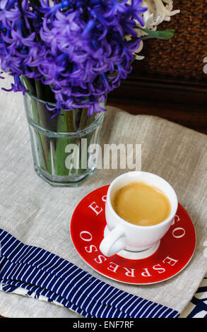 Coffee, sweets and spring flowers on dark stone background. Top view ...