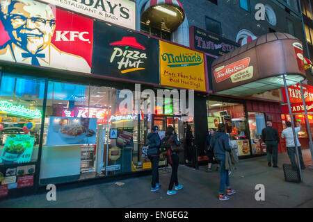 Signs for an assortment of fast food franchises located in one ...