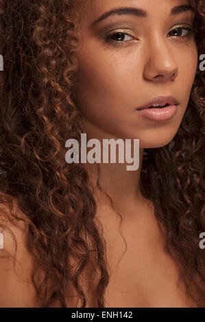 Portrait of beautiful thoughtful curly mixed race girl in casual style ...