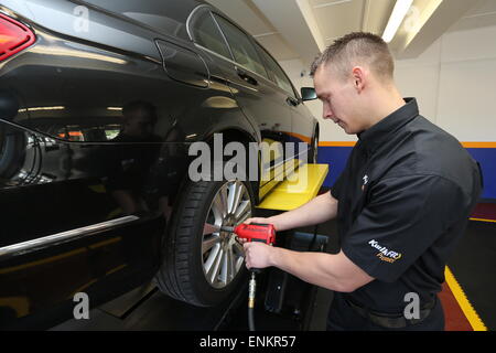 A Kwik Fit mechanic at work. Picture by James Boardman Stock Photo - Alamy