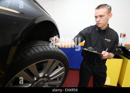 A Kwik Fit mechanic at work. Picture by James Boardman Stock Photo - Alamy