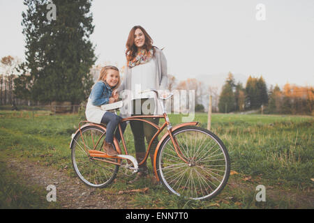 A mother and daughter pose with an old fashioned bicycle Stock Photo ...
