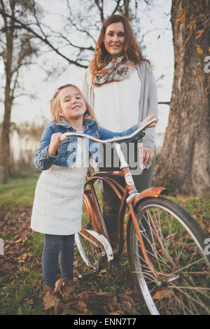 A mother and daughter pose with an old fashioned bicycle Stock Photo ...