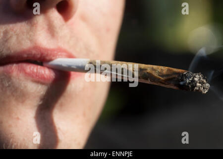 Close up, man smoking marijuana joint in the hand Stock Photo - Alamy