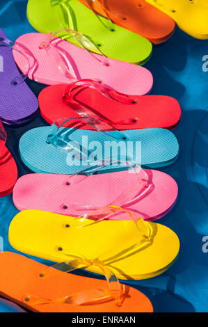 Multicolored flip flops floating in small pool Stock Photo - Alamy