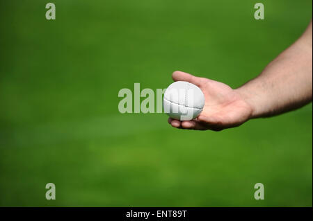 Hand holding a rounders ball. Rounders is a bat and ball game between ...